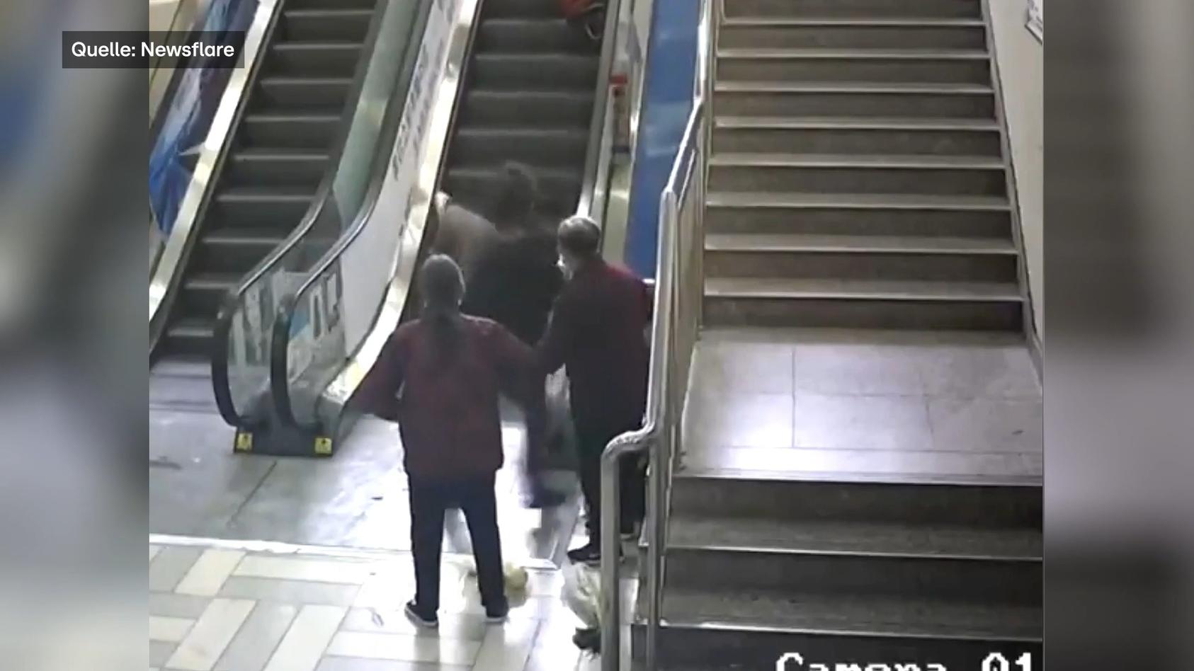 Schlimme Szene in China! Frau stürzt auf Rolltreppe - Mann eilt zur Hilfe